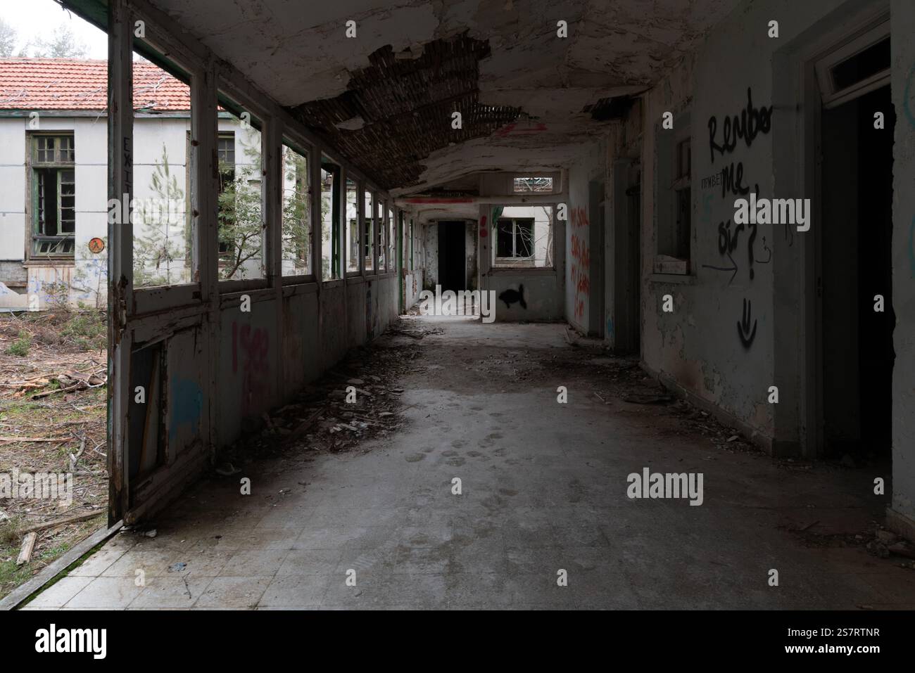 Deteriorated hallway in deserted hospital showing decay, vandalism, and ...