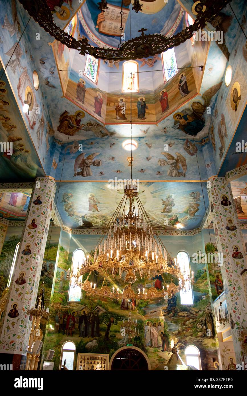 Interior of an orthodox russian church, with frescoes depicting biblical scenes, stained glass ...