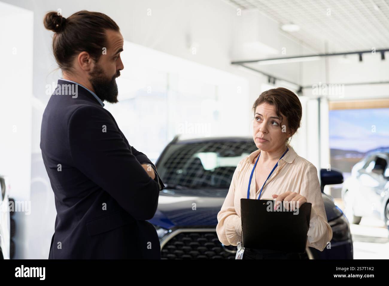 Car sales executive showcasing dealership vehicles to client ...