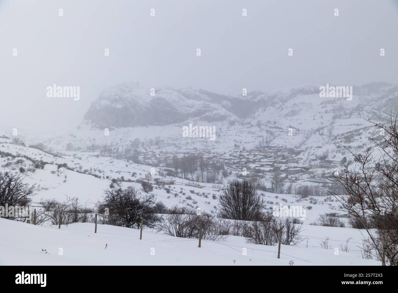 Serene winter view of a snow-covered village surrounded by mountains in ...