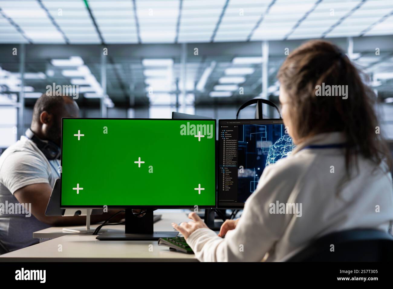 Isolated screen PC in front of IT support workers upgrading AI equipment. Engineers at PC desk ...