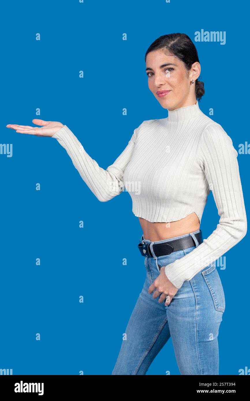 Young woman showing and presenting with open hand palm up on a blue ...