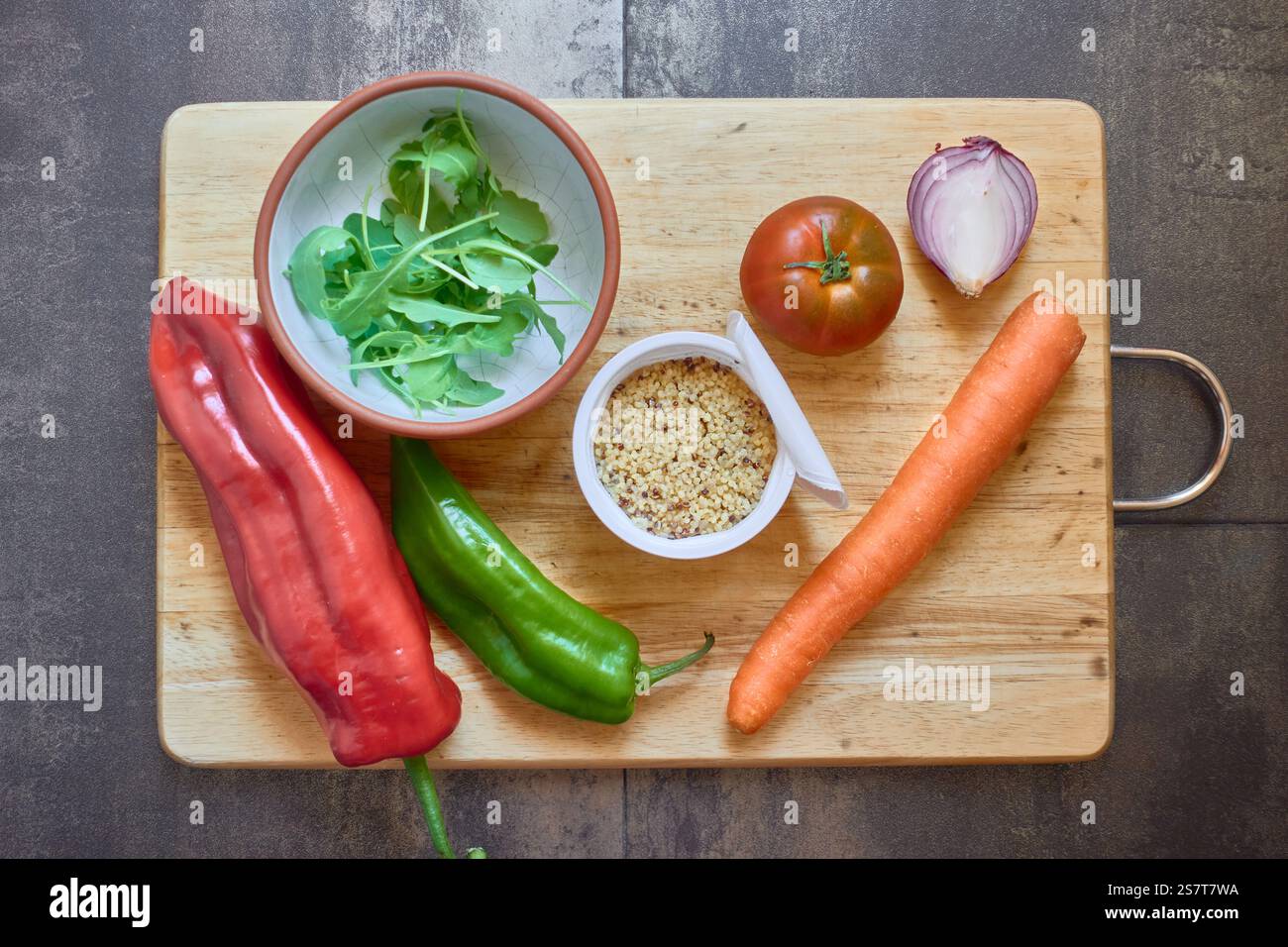 Cutting board with ingredients to prepare a quinoa salad on metal ...