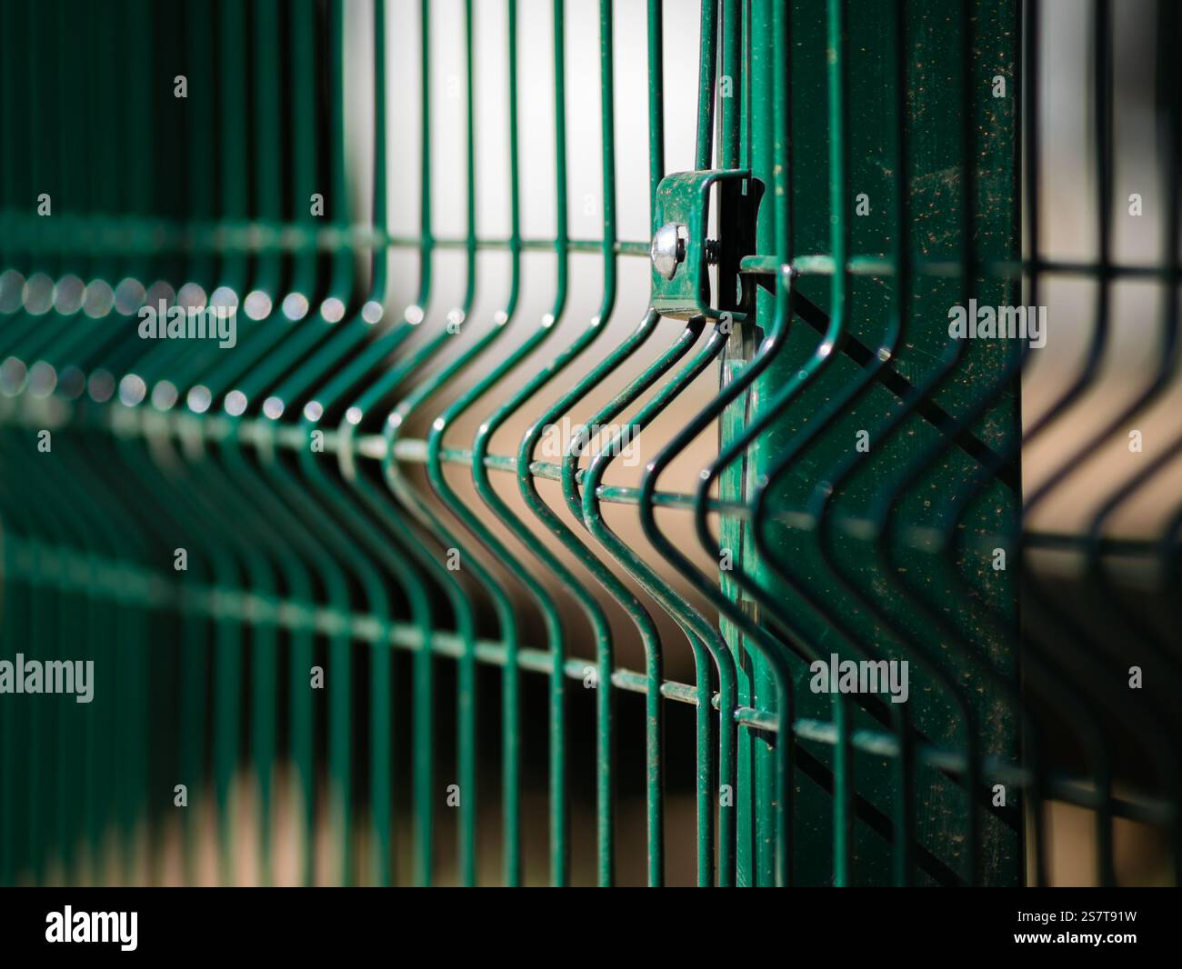 Selective focus on a column of metal mesh fence with rectangular cells ...