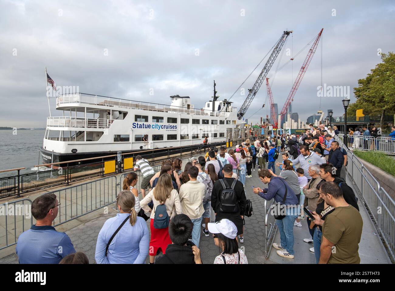 Queue of people boarding for a boat cruise to Statue of Liberty and ...