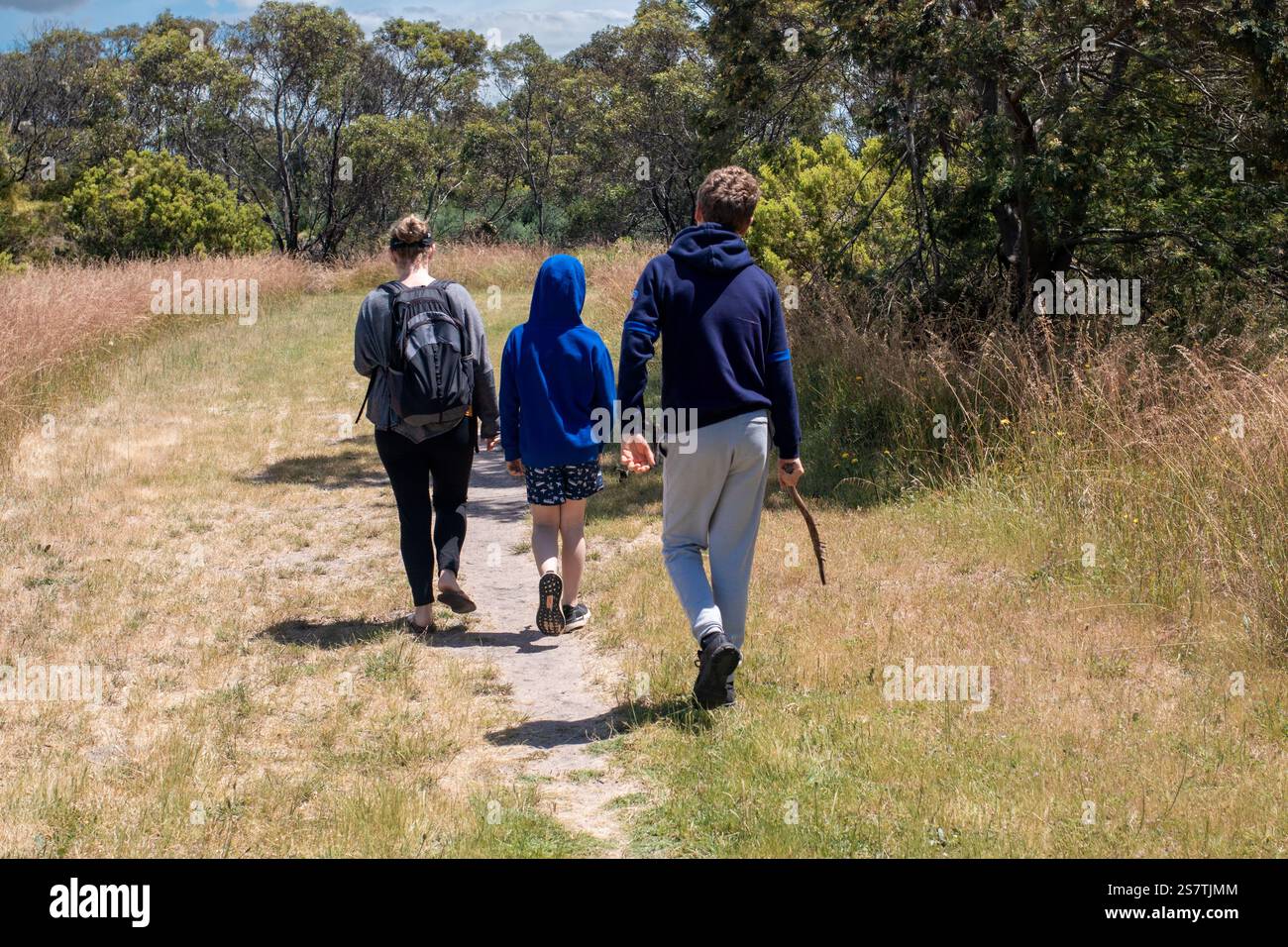 Family of Three people walking on a grassy bush trail in Australia ...
