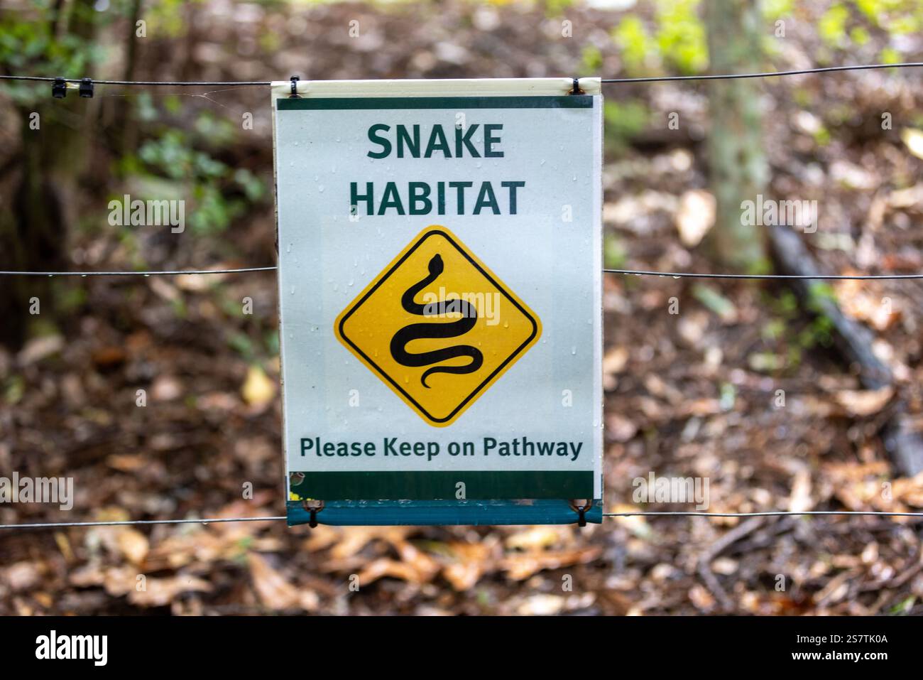 Snake habitat warning sign on a fence in an Australian bush forest ...