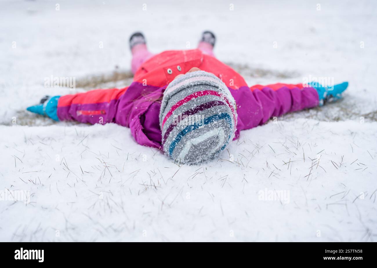 Child making snow angel on a snowy day Stock Photo - Alamy
