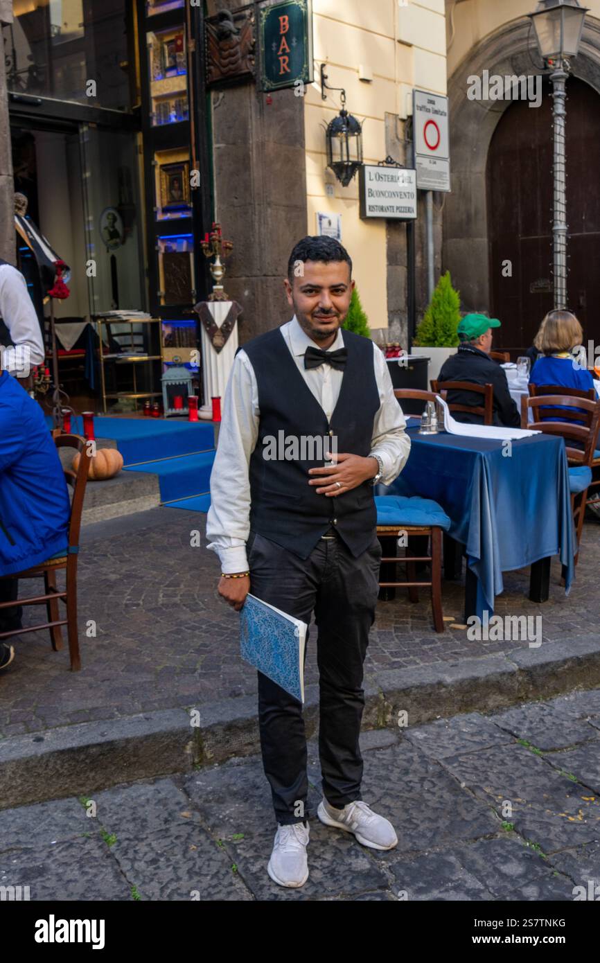 A waiter poses for a picture in front of a restaurant in Sorrento ...