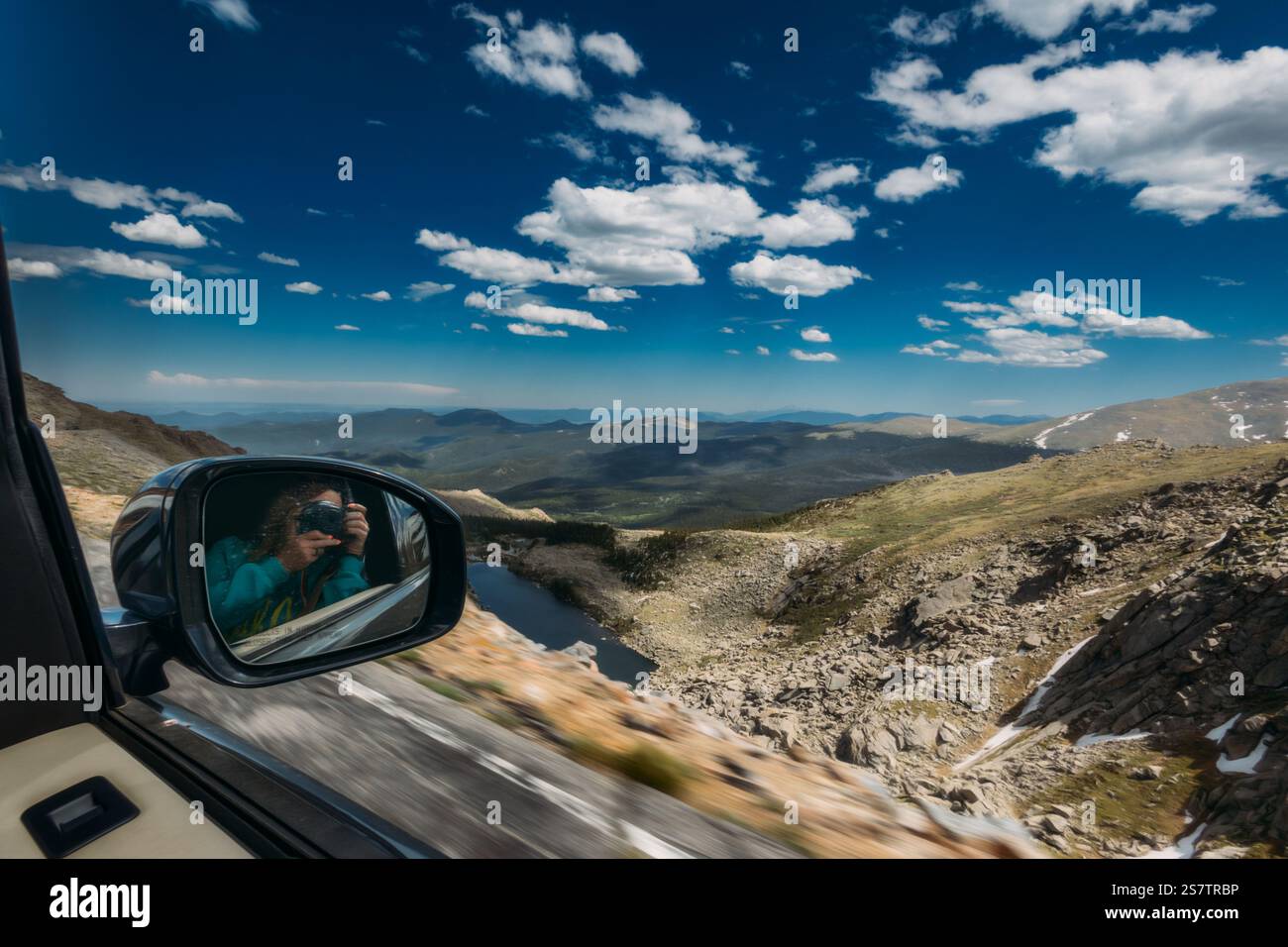 Passenger taking photograph outside car window of mountain range Stock ...