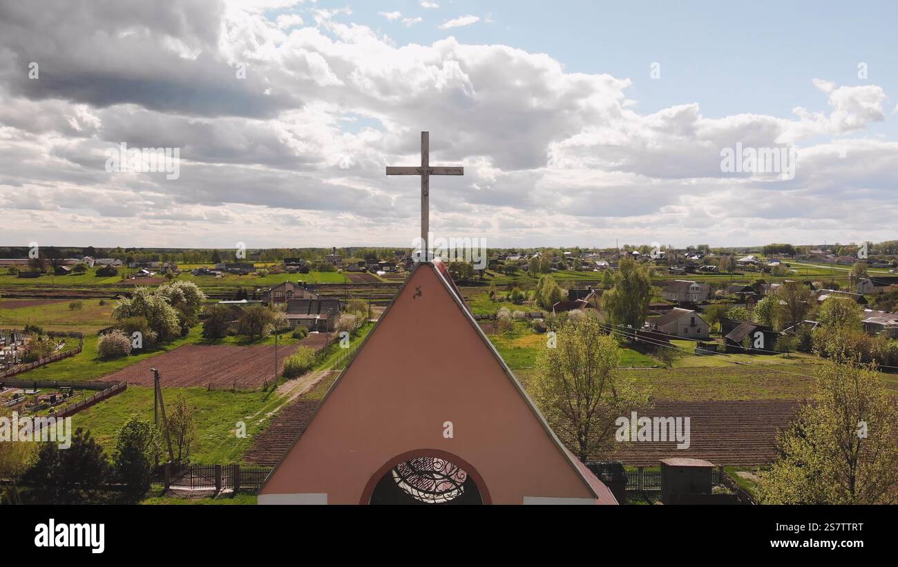 Wooden cross topping church roof, overlooking rural landscape with ...
