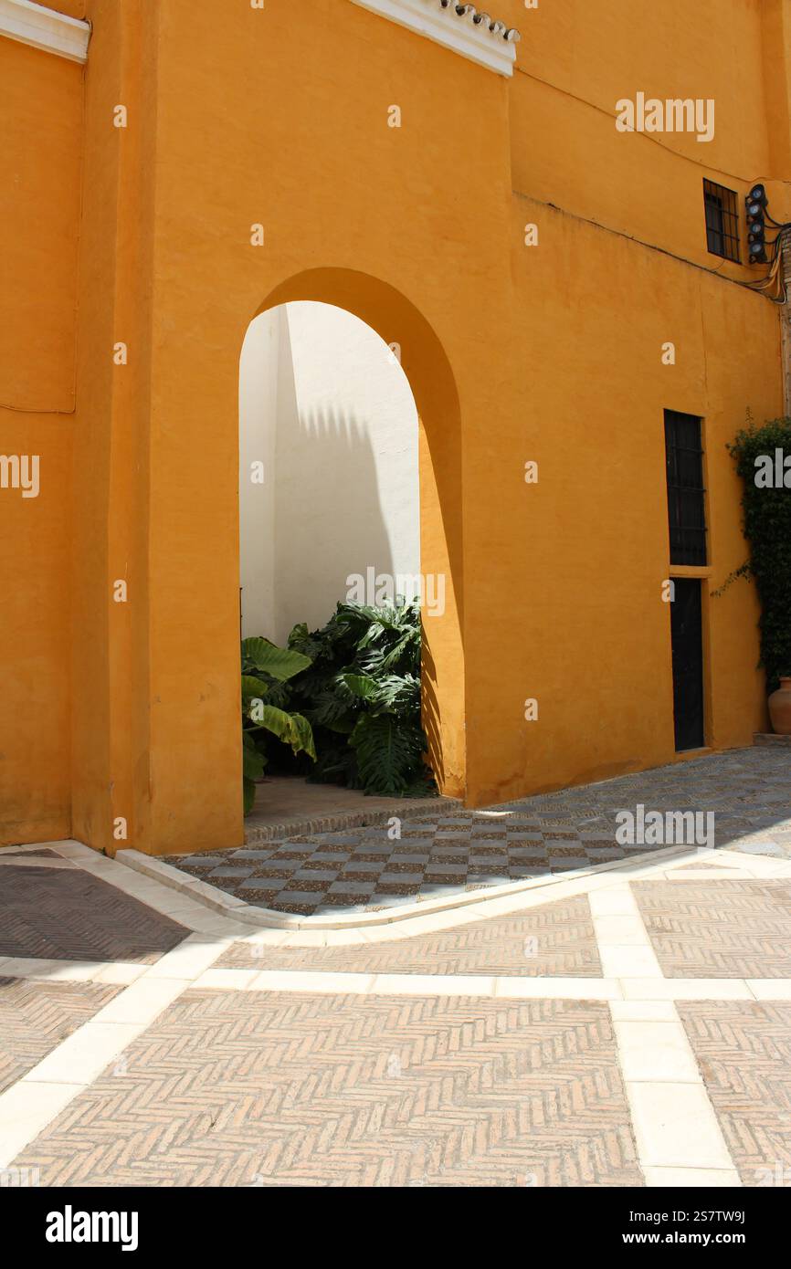 Orange arch with statue in Real Alcazar gardens Stock Photo - Alamy