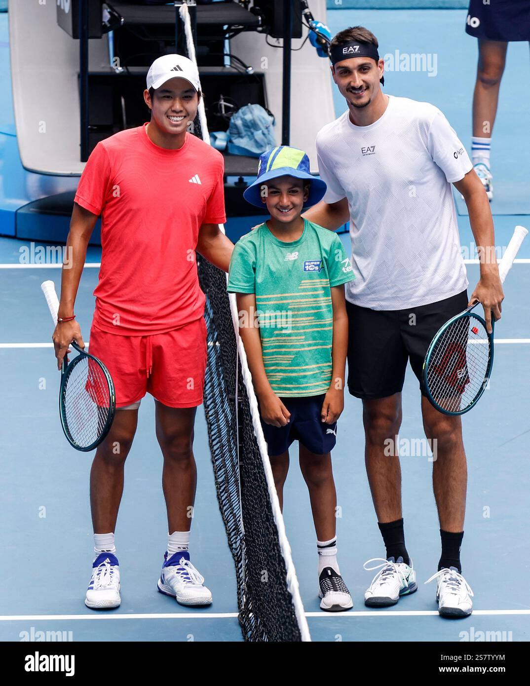 Melbourne, Australia. 20th Jan, 2025. Lorenzo Sonego (R), Learner Tien (L) and a ballboy take ...