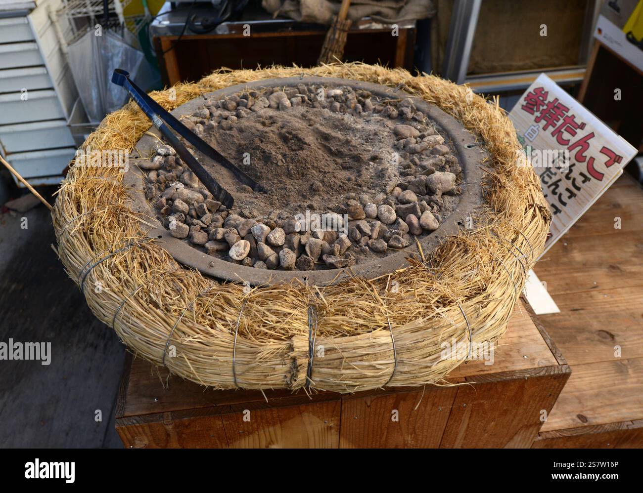 A traditional cooking pot covered with straw and filled with earth ...