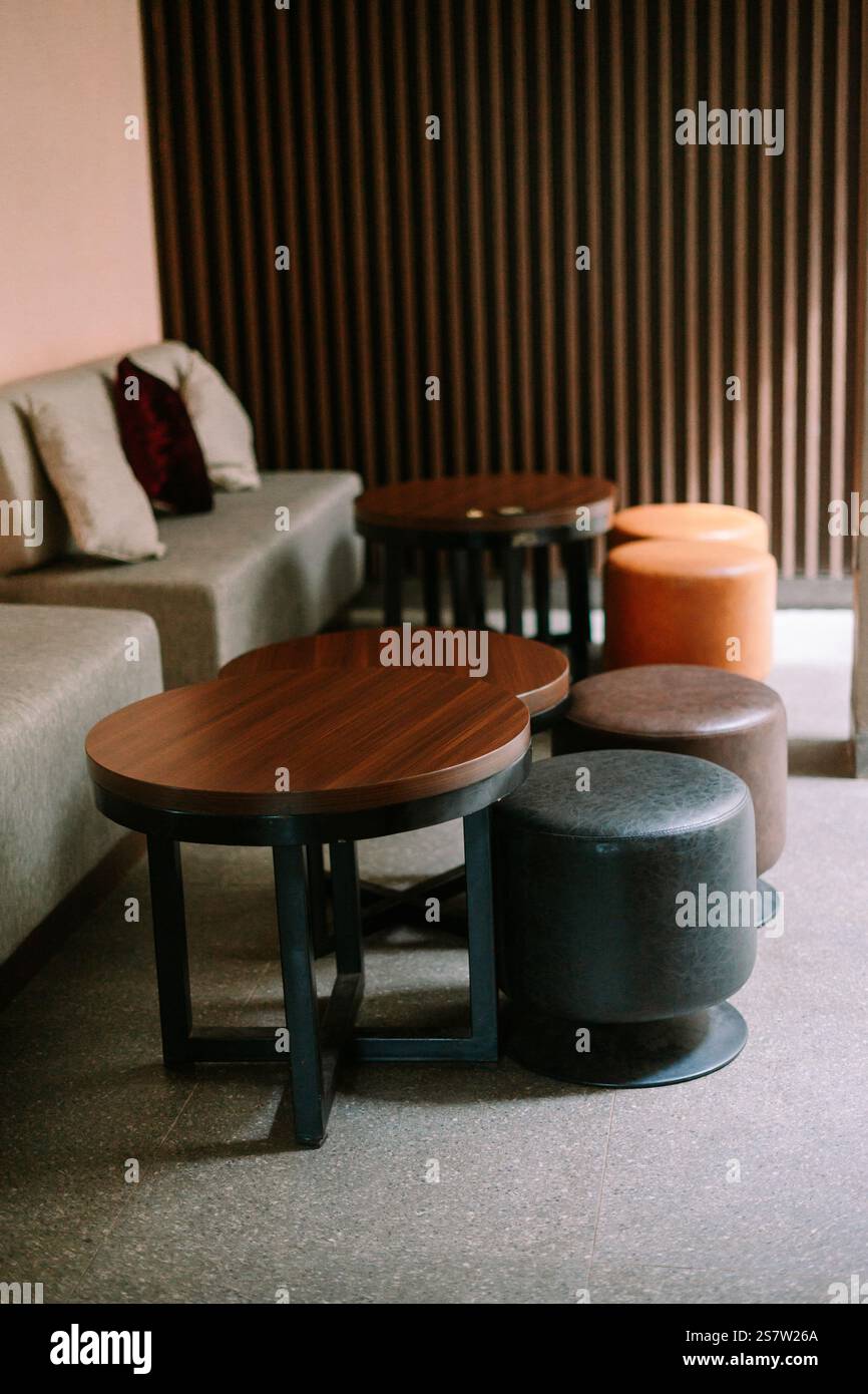 Stylish lounge area with round wooden tables and comfortable seating ...