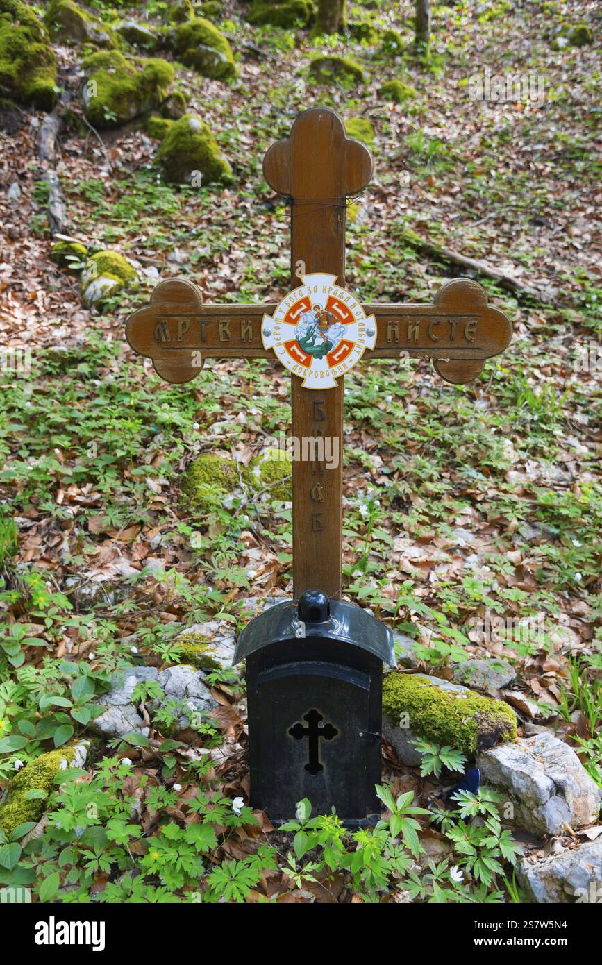 Orthodox wooden cross with inscription surrounded by forest landscape ...
