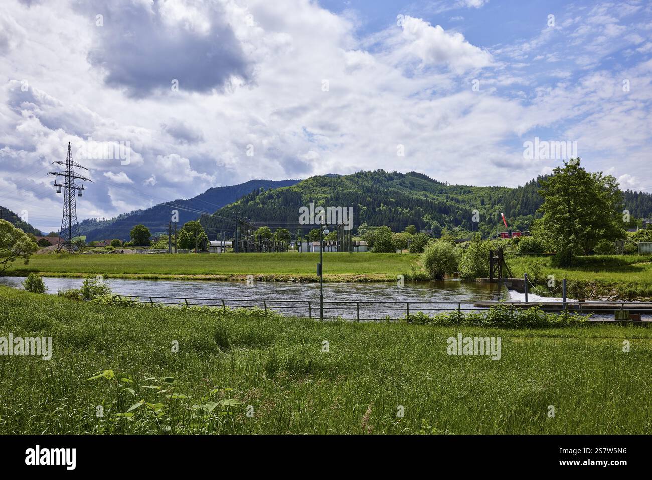 River Kinzig, bank with meadow and trees, electricity pylon, hilly ...