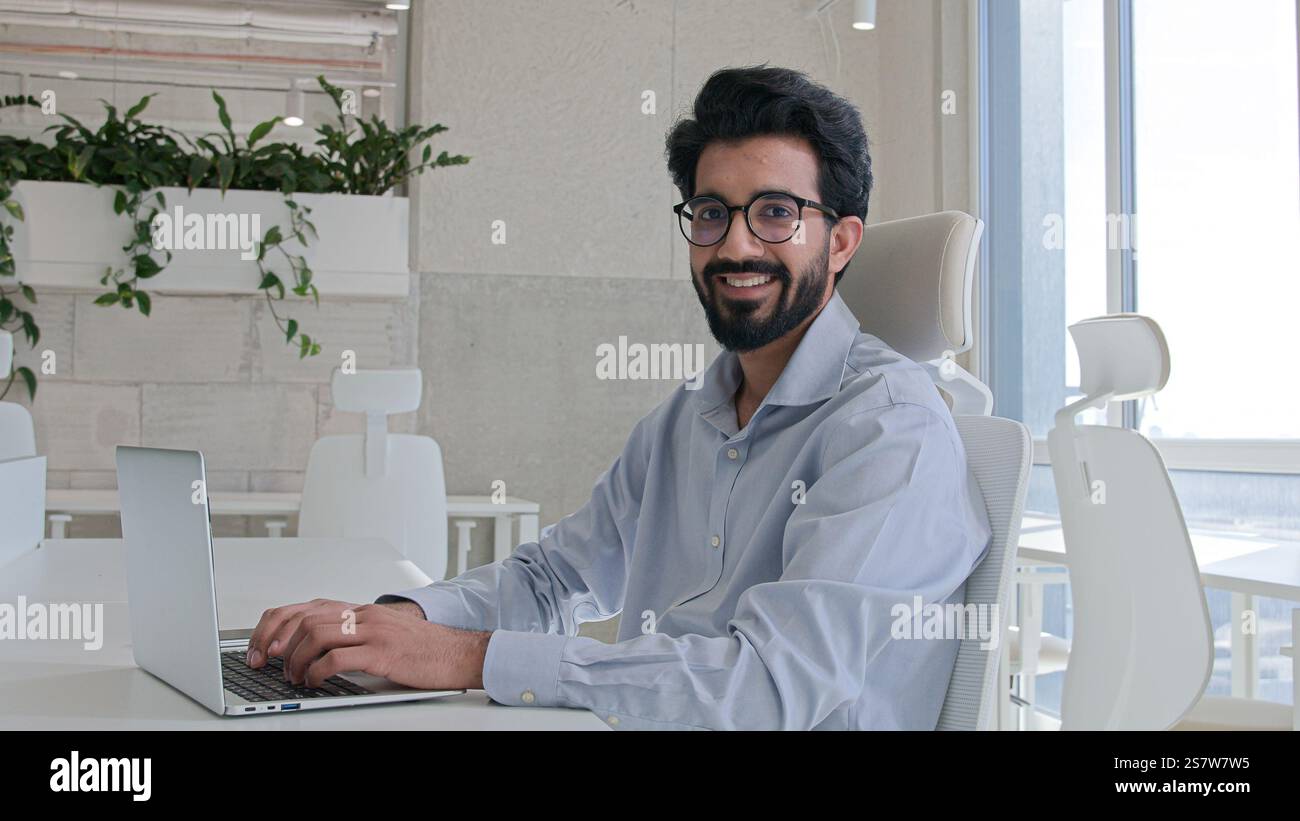 Arabian Indian muslim businessman ethnic man working with computer at corporate office cheerful ...