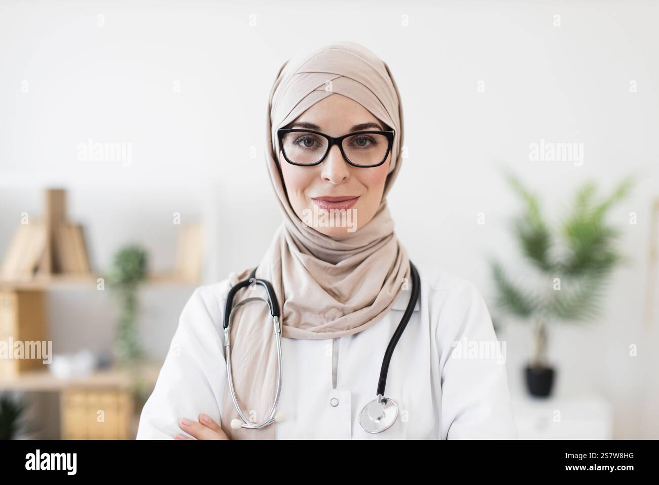 Portrait of a young Muslim woman doctor wearing hijab and glasses ...