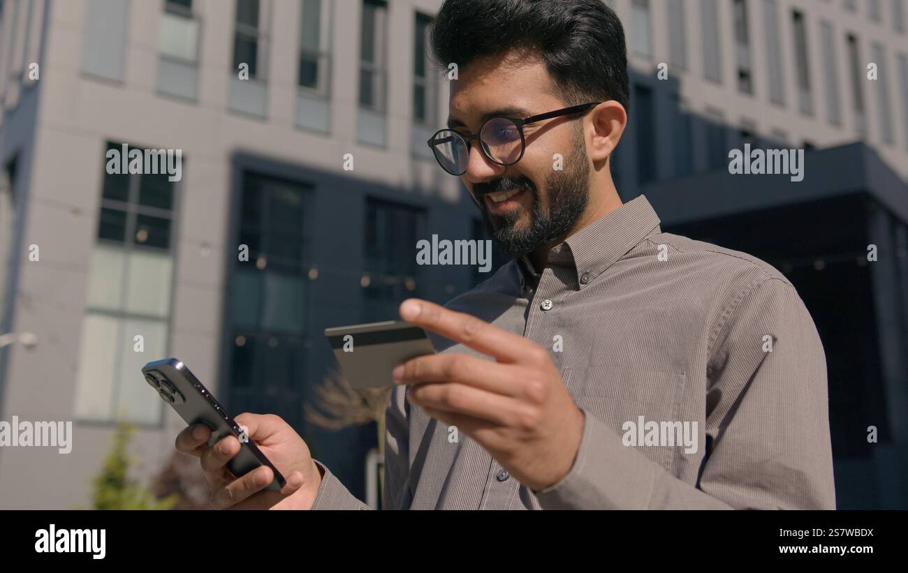 Arabian Indian man businessman hold bank credit card pay purchases with ...