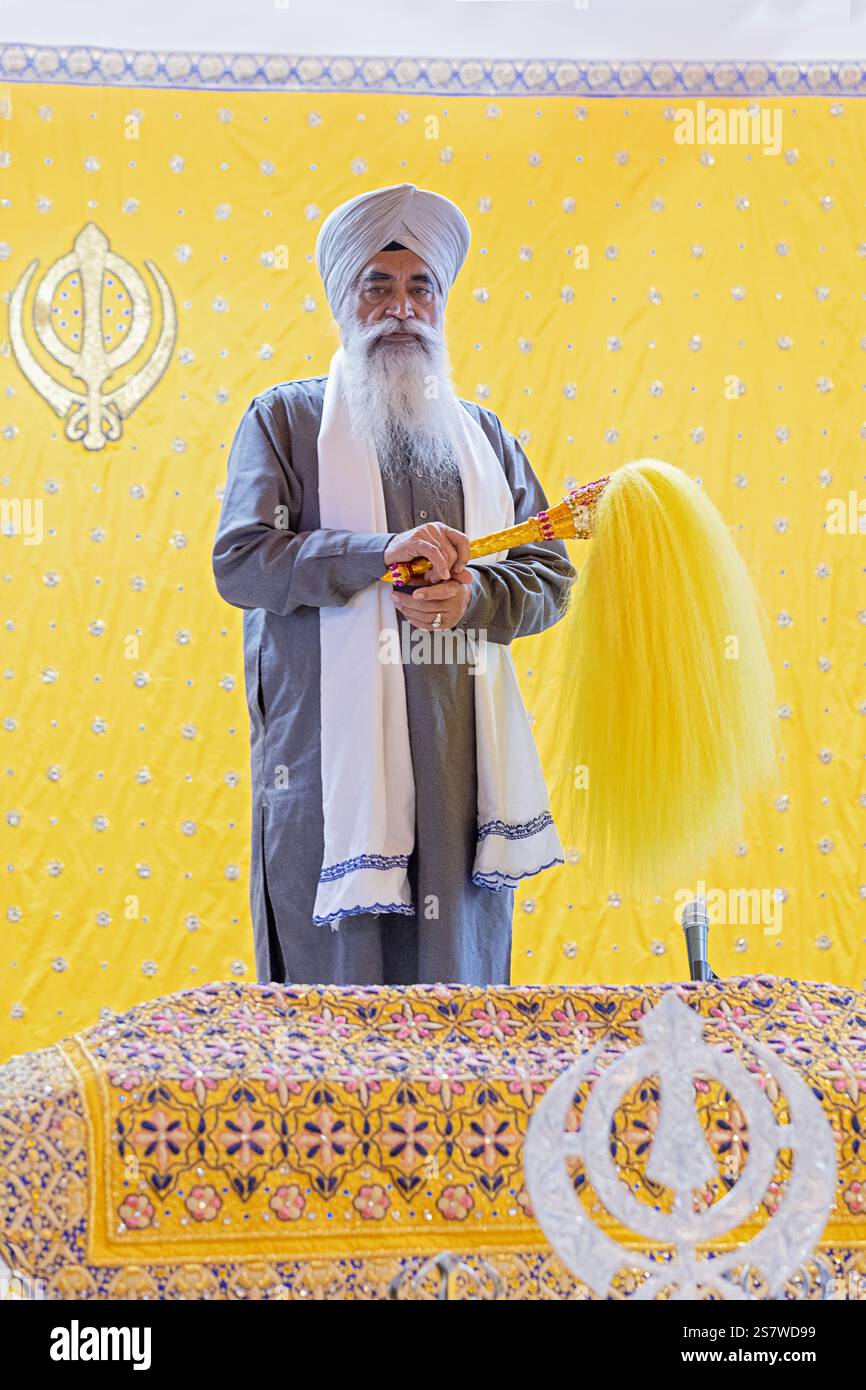A Sikh priest a holds a Chaur Sahib to wave over the bible ...