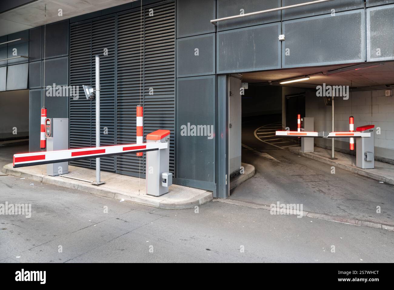 Modern parking garage entrance featuring automated barriers, security ...