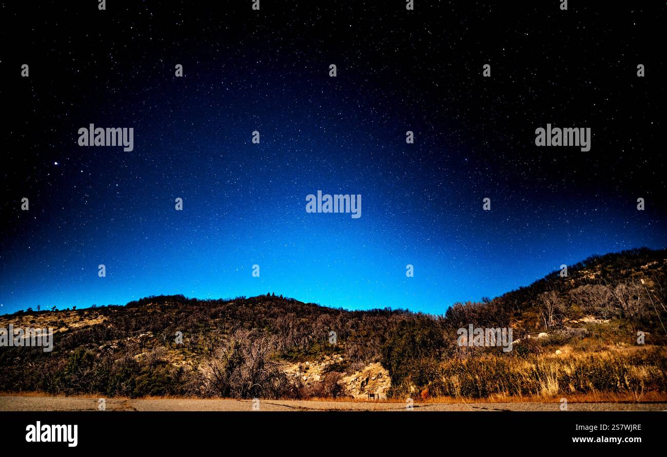 Starry sky above mountain range illuminated by moonlight ...