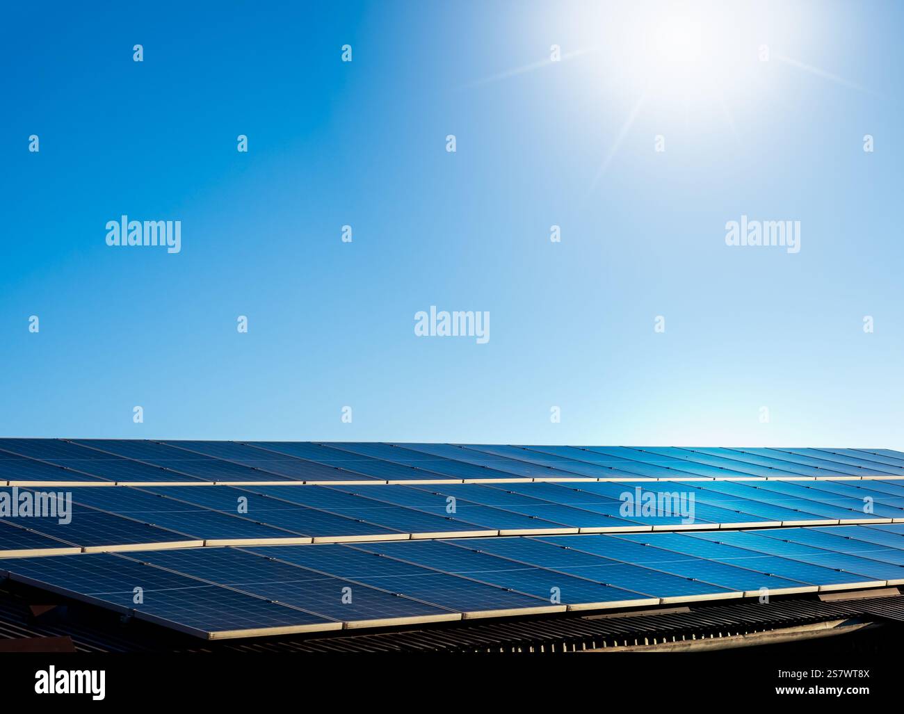 Solar panels on home rooftop with sunlight on blue sky background with ...