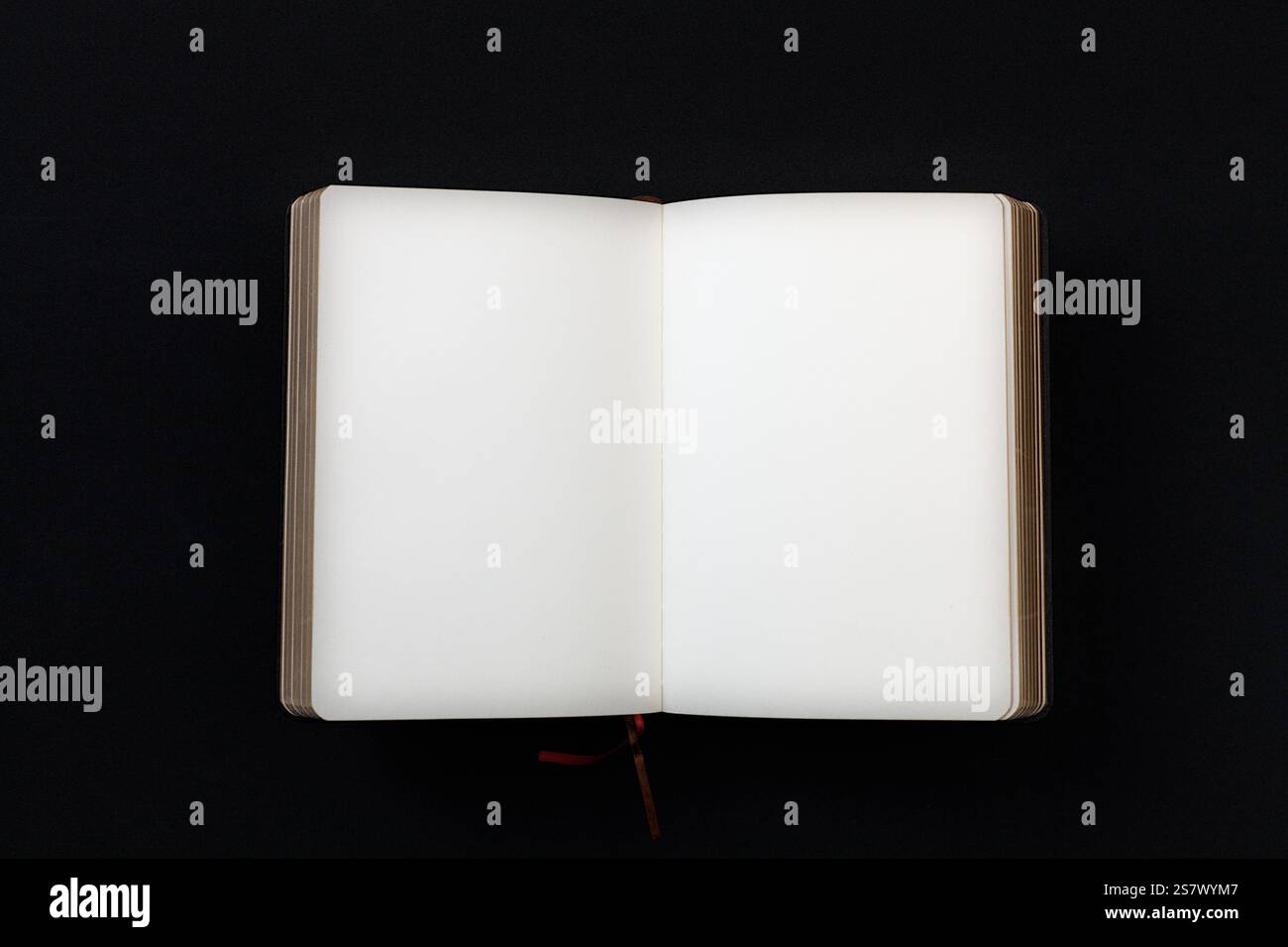 Open blank notebook with crisp white pages against a black background ...