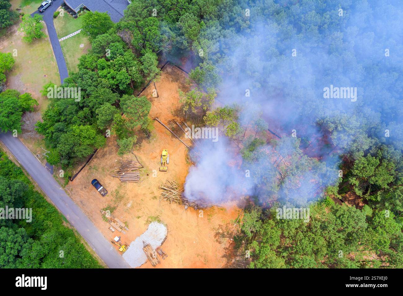 Controlled burn creates smoke as land clearing occurs in forested area ...