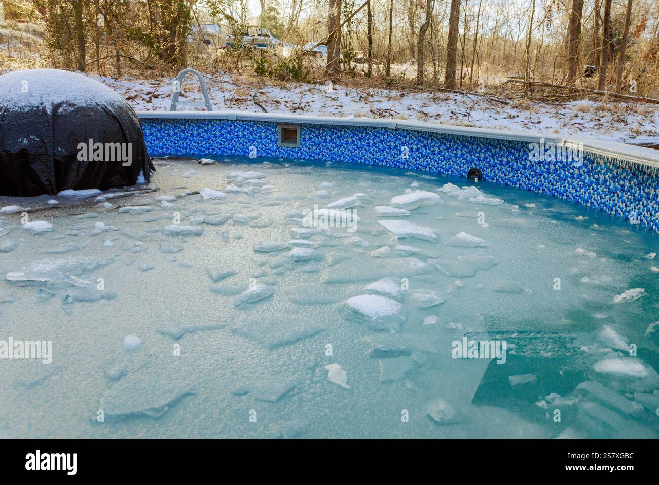 Ice covers surface of swimming pool, reflecting cold winter ...