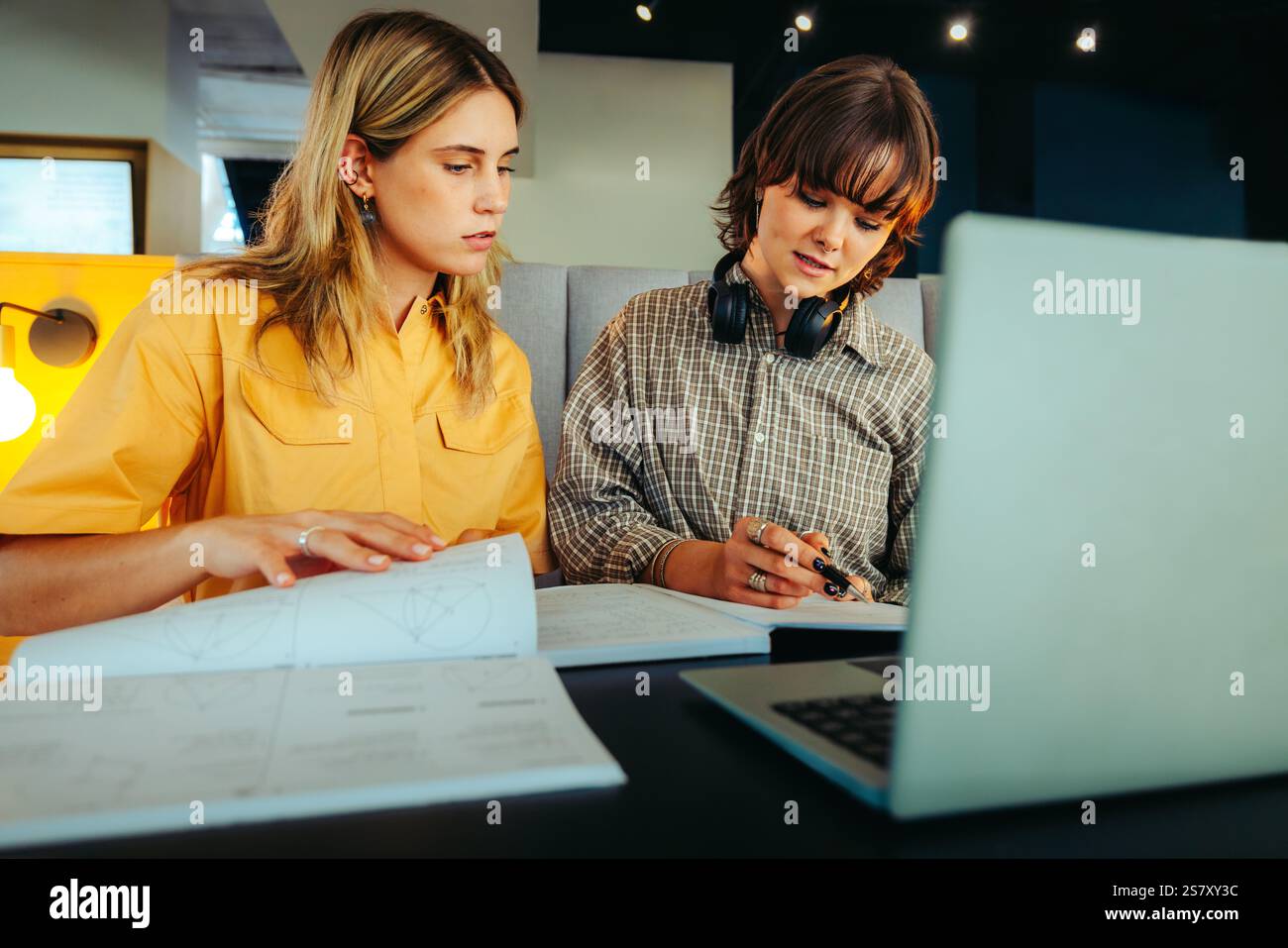 Two students working together on a project in a study area, emphasizing group work, learning ...