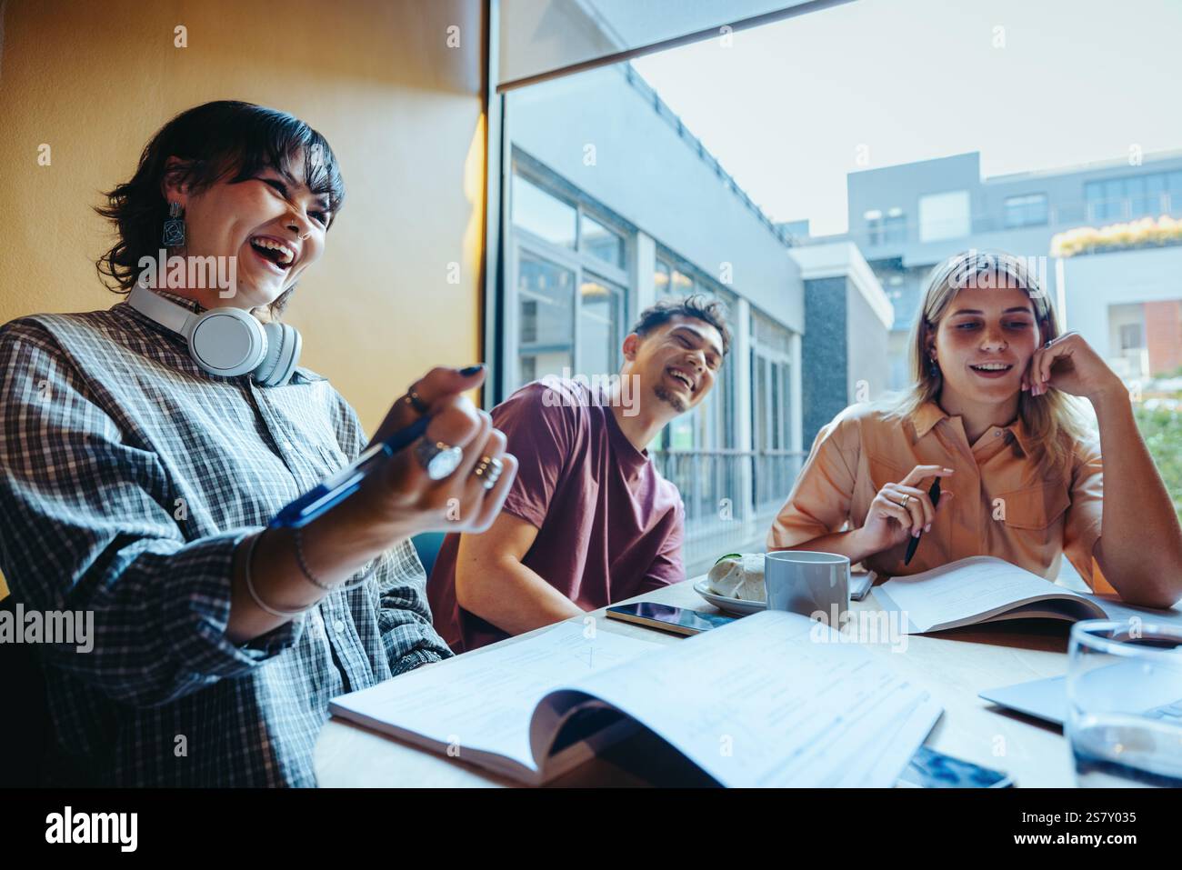 A group of college students laughing and learning together ...