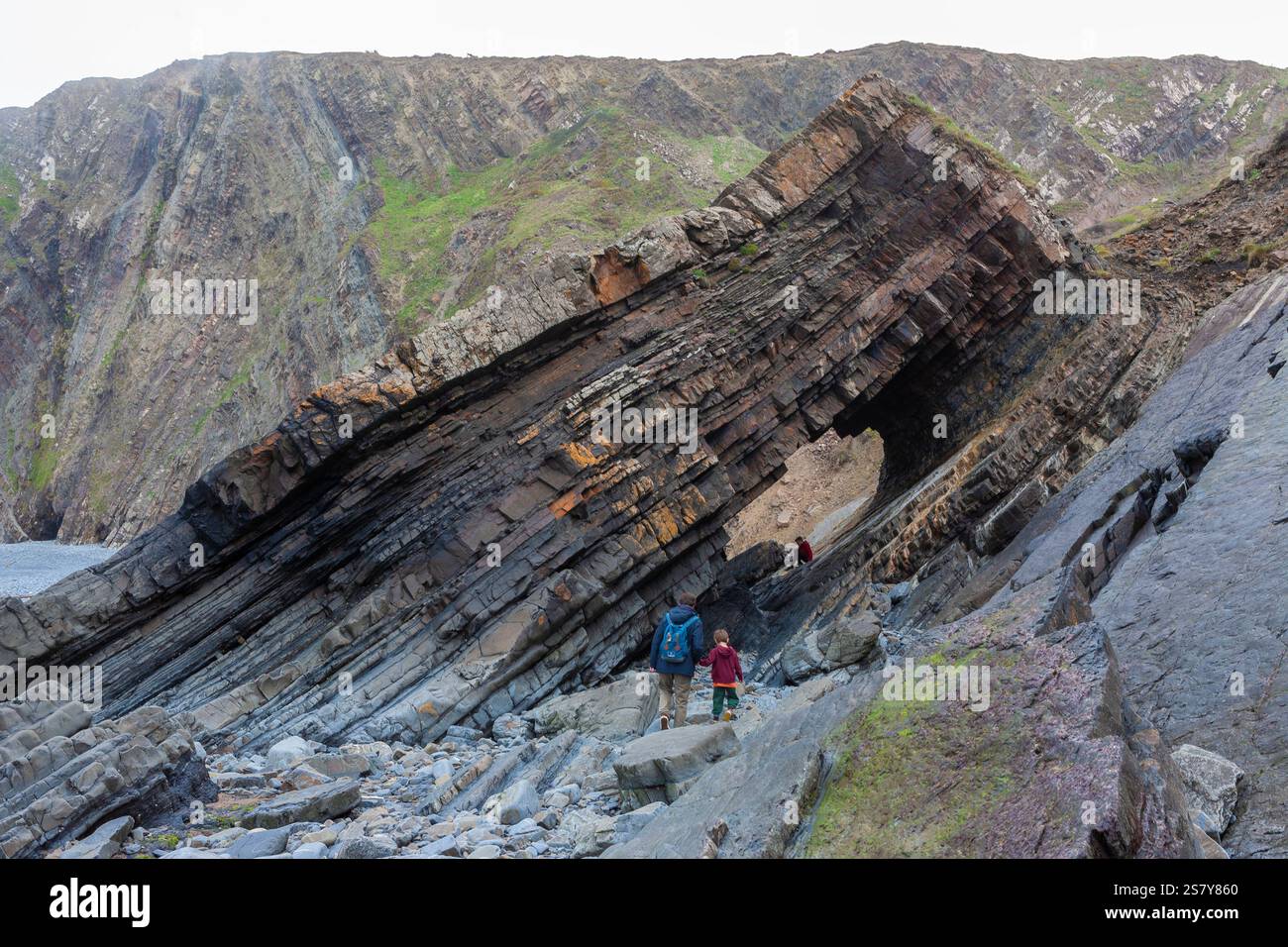 Visitors inspect the spectacular natural arch, Tunnel Rock, formed in ...