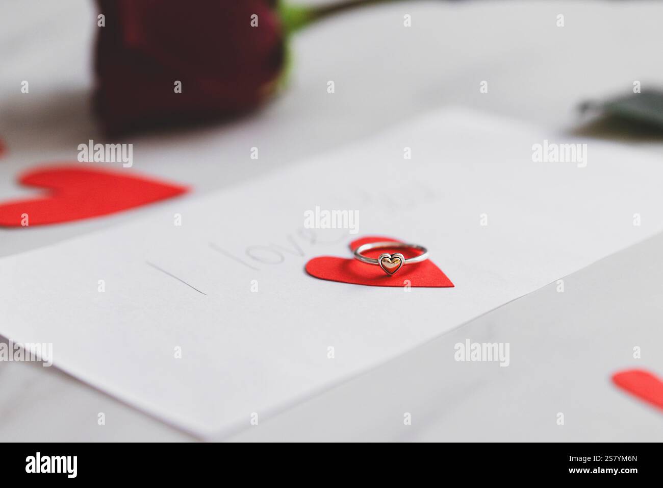 Heartfelt proposal on a handwritten note with a ring on a red paper ...