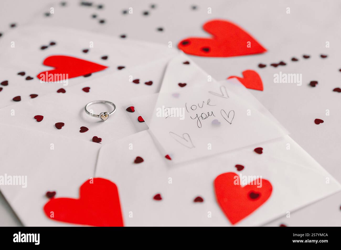Heartfelt proposal on a handwritten note with a ring on a red paper ...