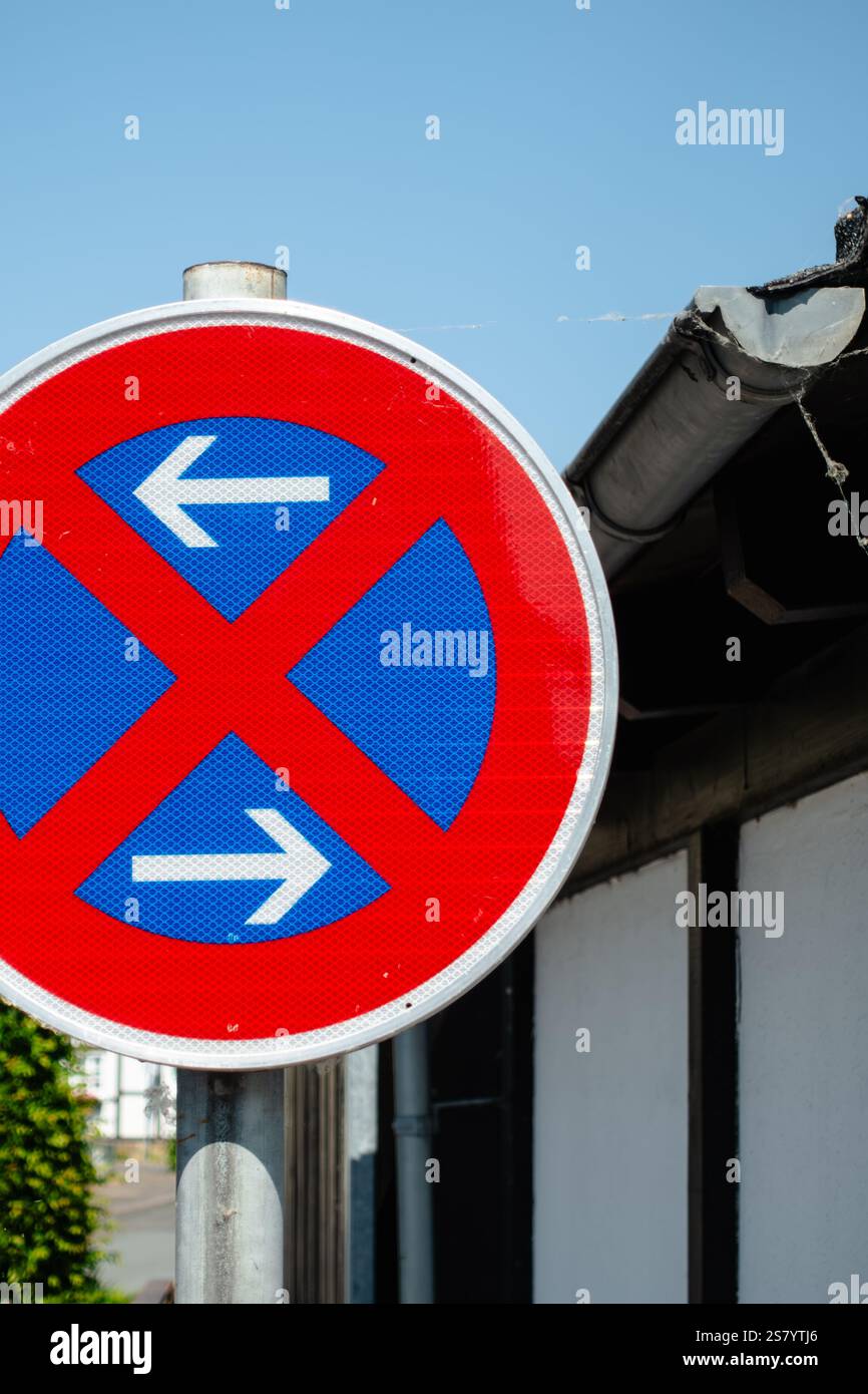 A red and blue sign with an arrow pointing to the left and a red X. The ...