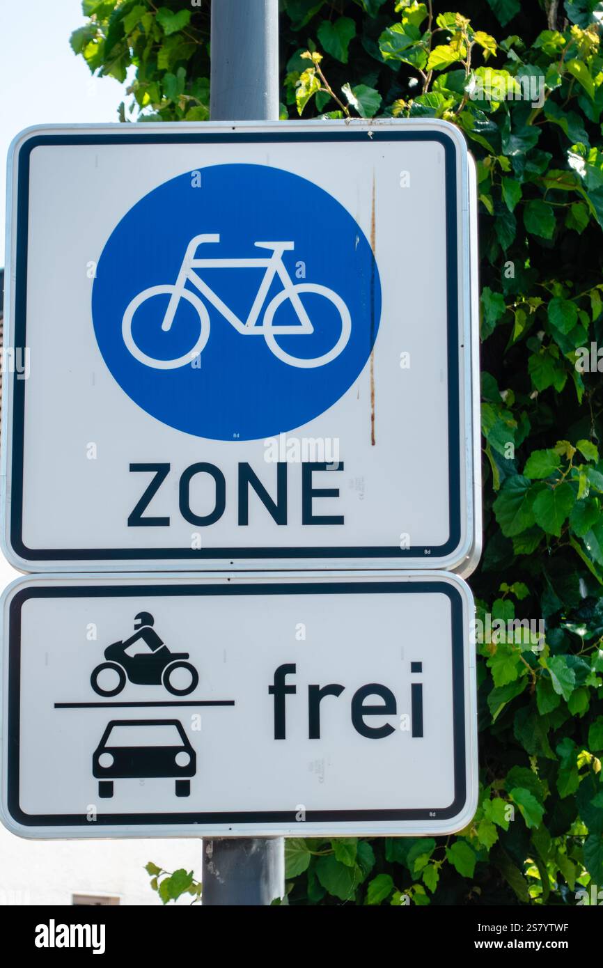 A sign with a blue circle and a bicycle on it. The sign says "Zone" and ...