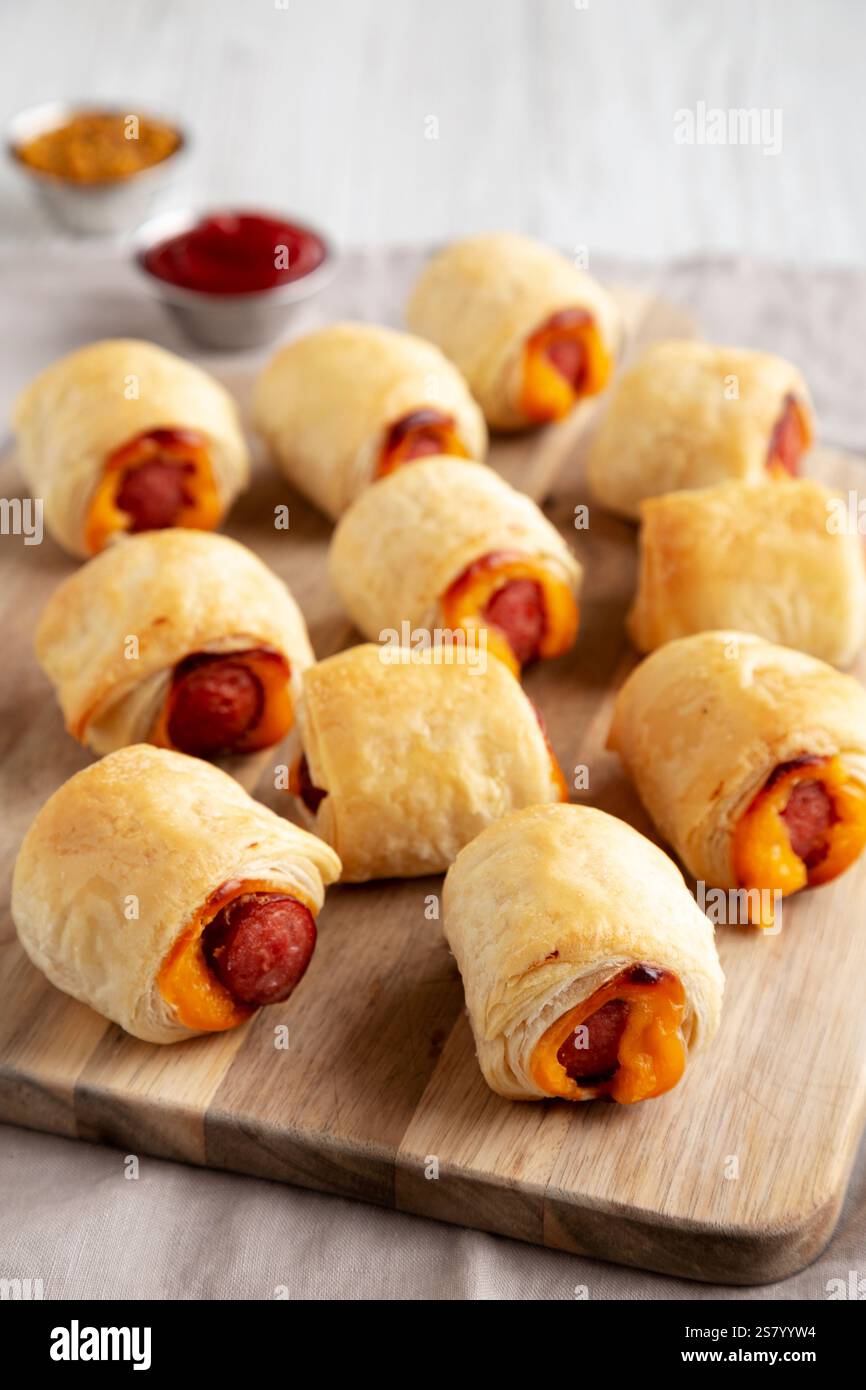 Homemade Pigs in a Blanket with Ketchup and Mustard on a Wooden Board ...