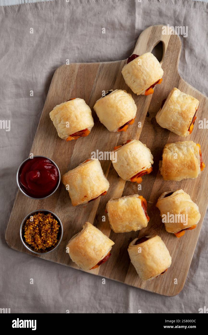 Homemade Pigs in a Blanket with Ketchup and Mustard on a Wooden Board ...