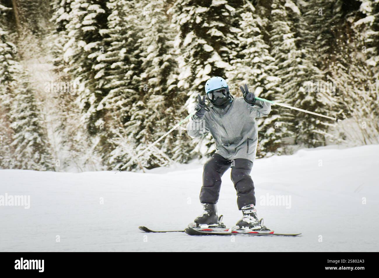 Young male child skier pose show V signs while learning to ski in ...