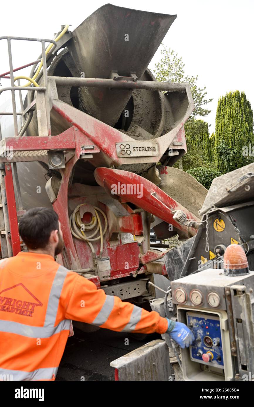 Ready mixed truck unloading concrete into concrete pumping system at ...