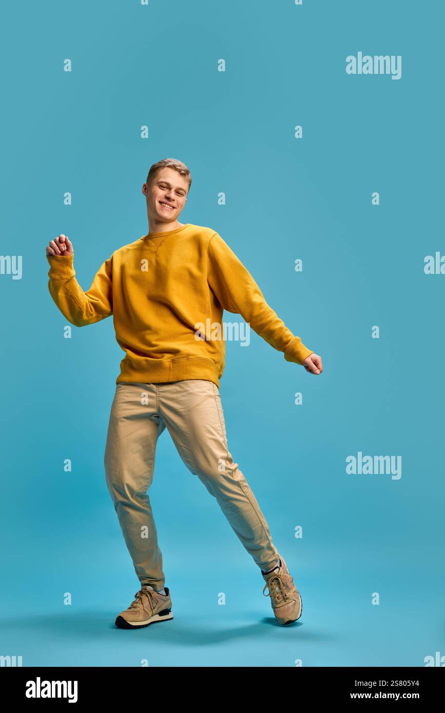 Man mid-dance, shifting confidently with playful energy, smiling as he ...