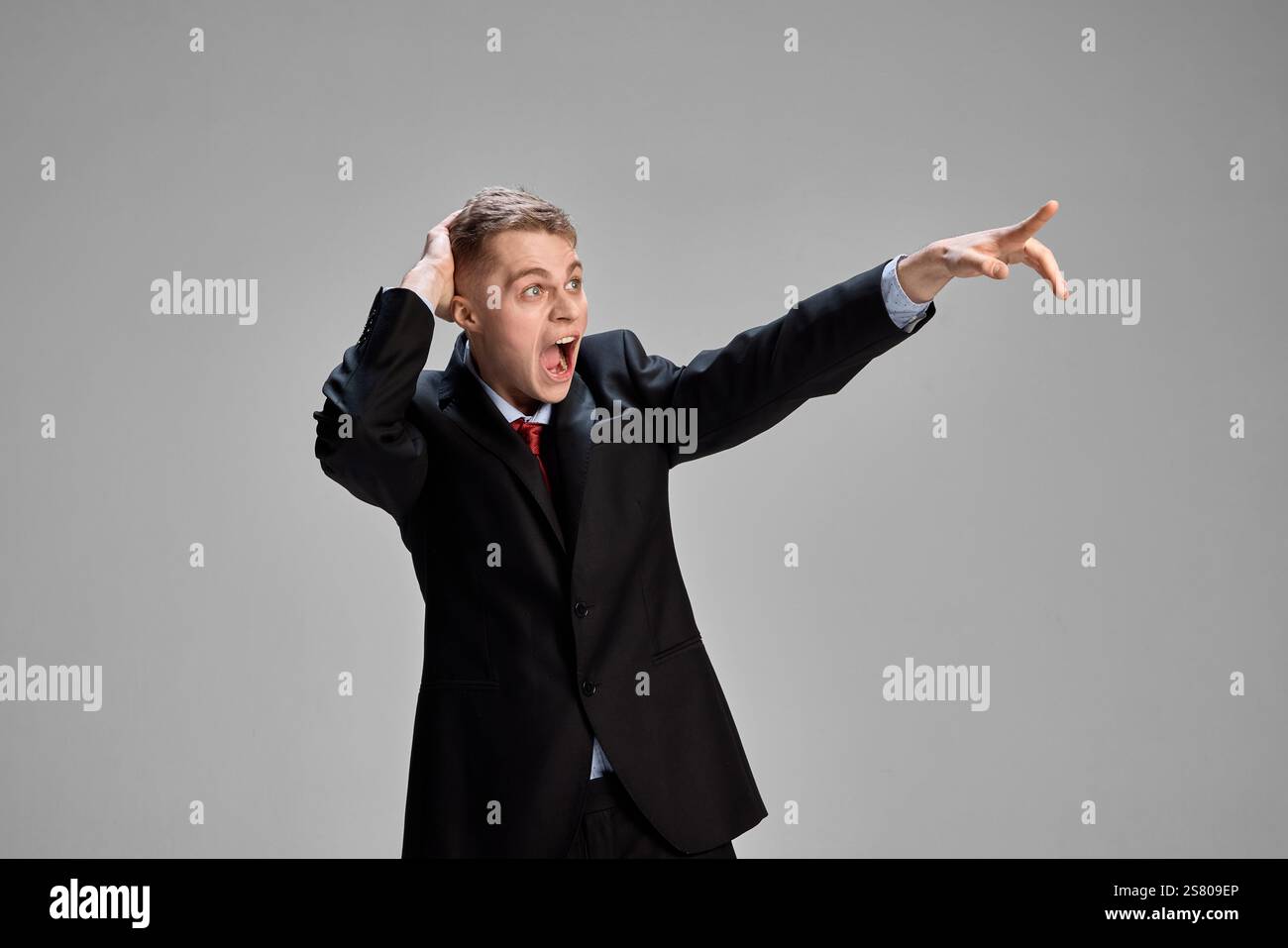 Man pointing dramatically with one hand while holding his head with ...