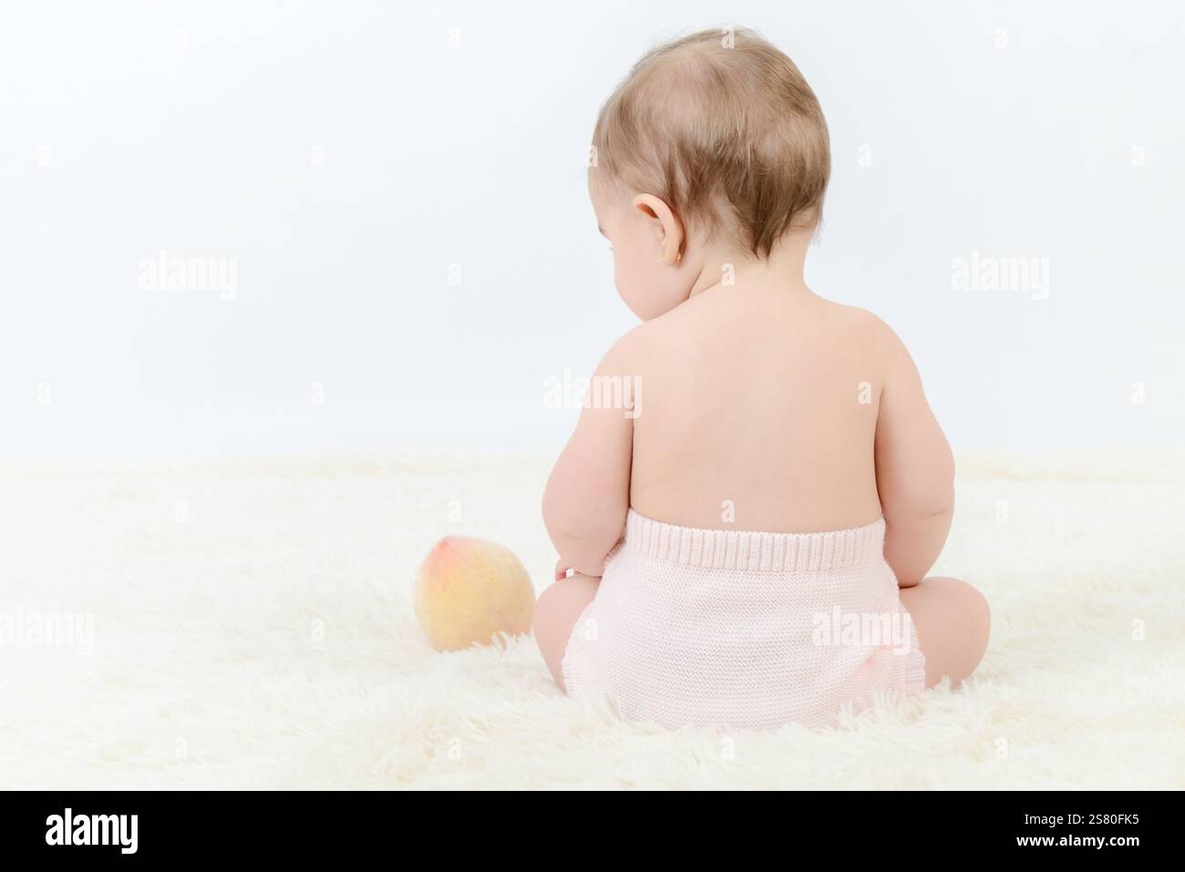 cute little girl sitting on her back on the soft white floor Stock ...