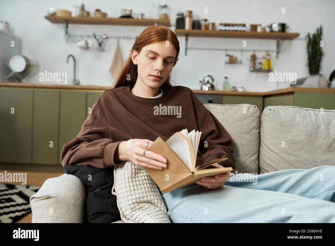 Young man enjoys a quiet moment reading in his stylish home while ...