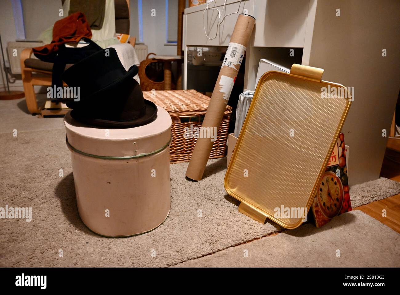 a top hat a bowler hat a gold coloured tea tray and a wicker hamper ...