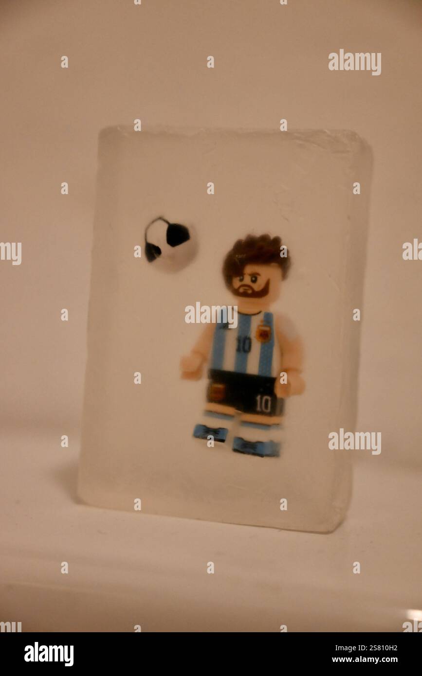 a lego style mini figure of lionel messi encased inside a clear bar of ...