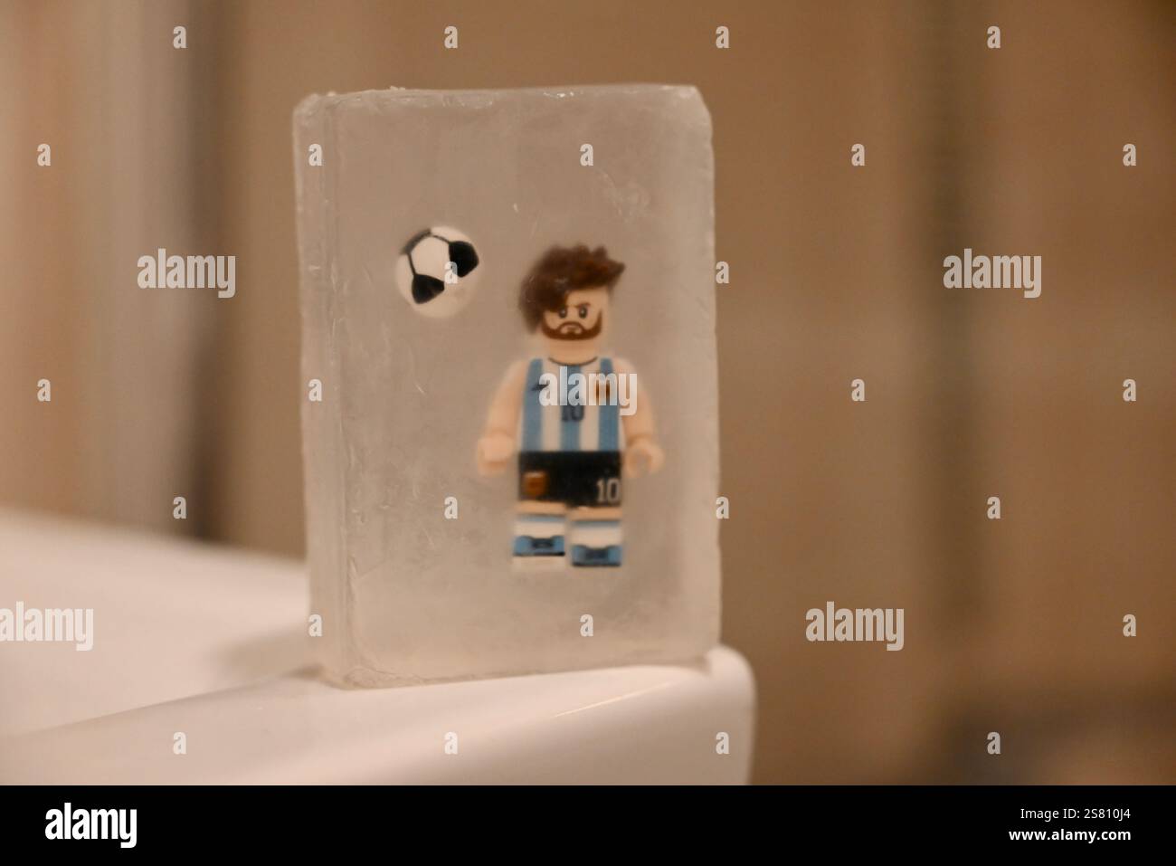 a lego style mini figure of lionel messi encased inside a clear bar of ...