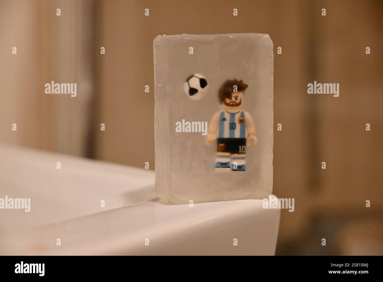 a lego style mini figure of lionel messi encased inside a clear bar of ...